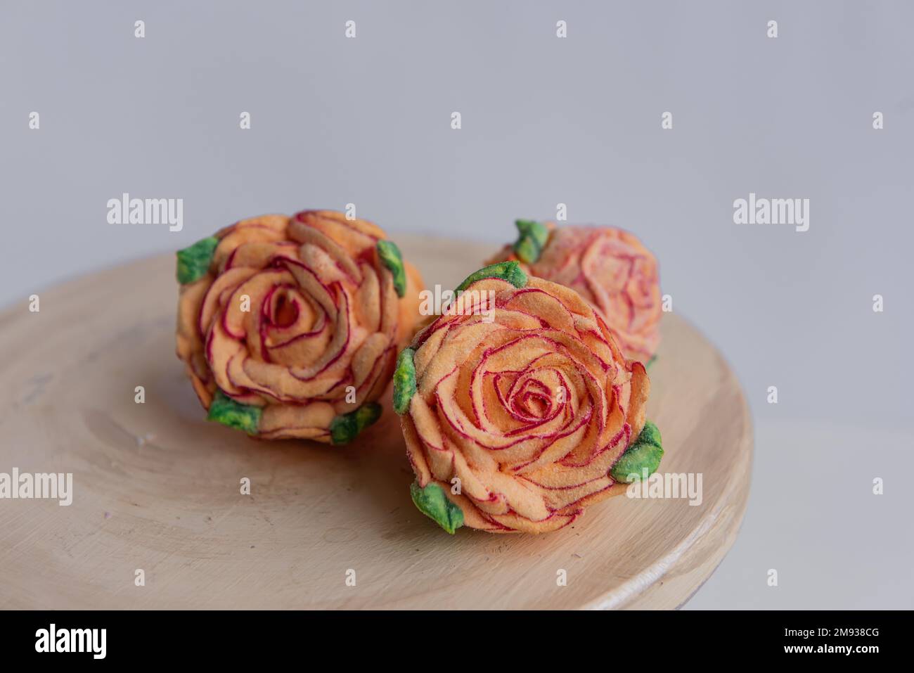 On a wooden round background lie natural orange marshmallows in the ...