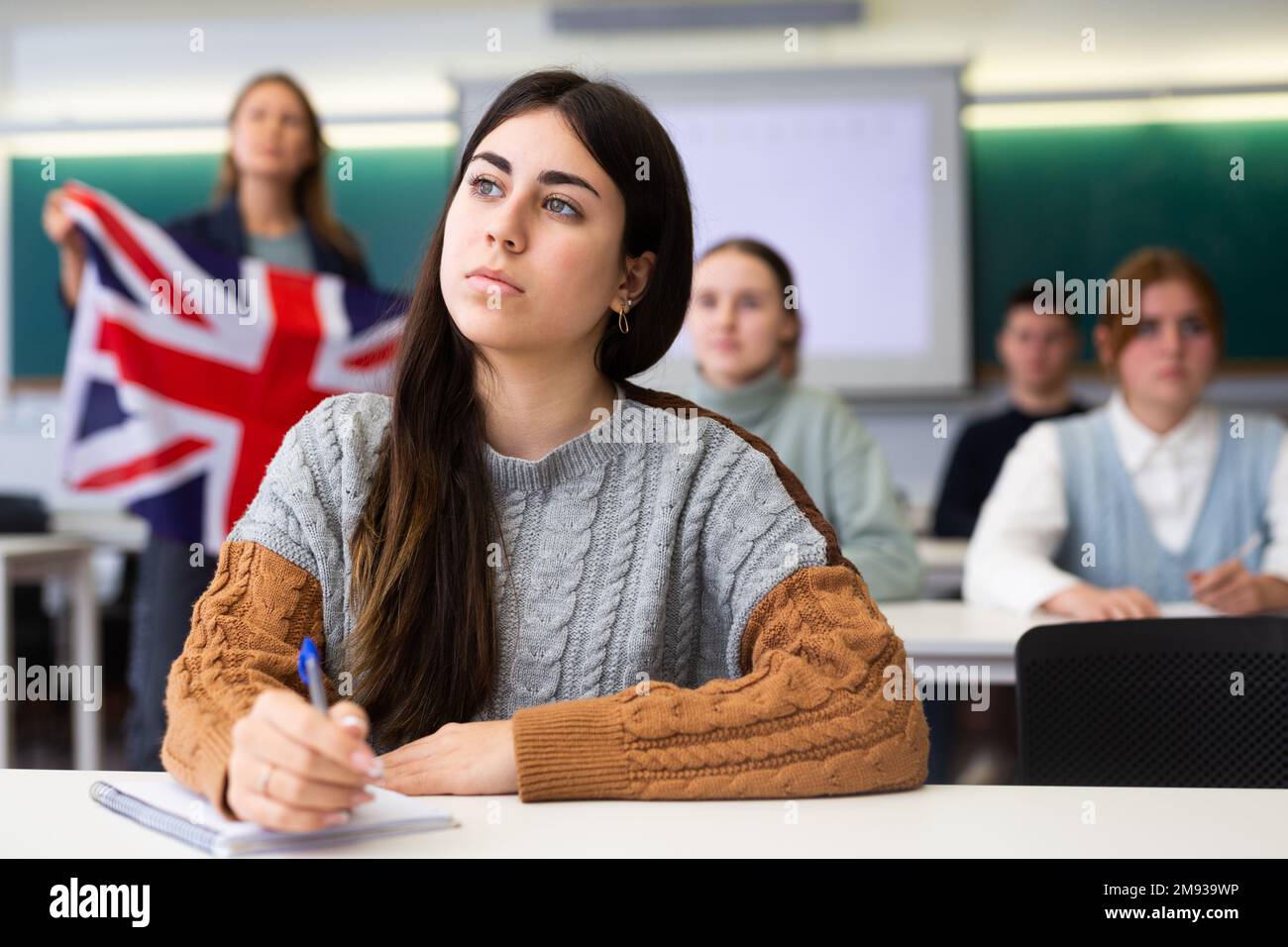 Teacher talks about the country and the national flag of Great Britain in a geography lesson ...