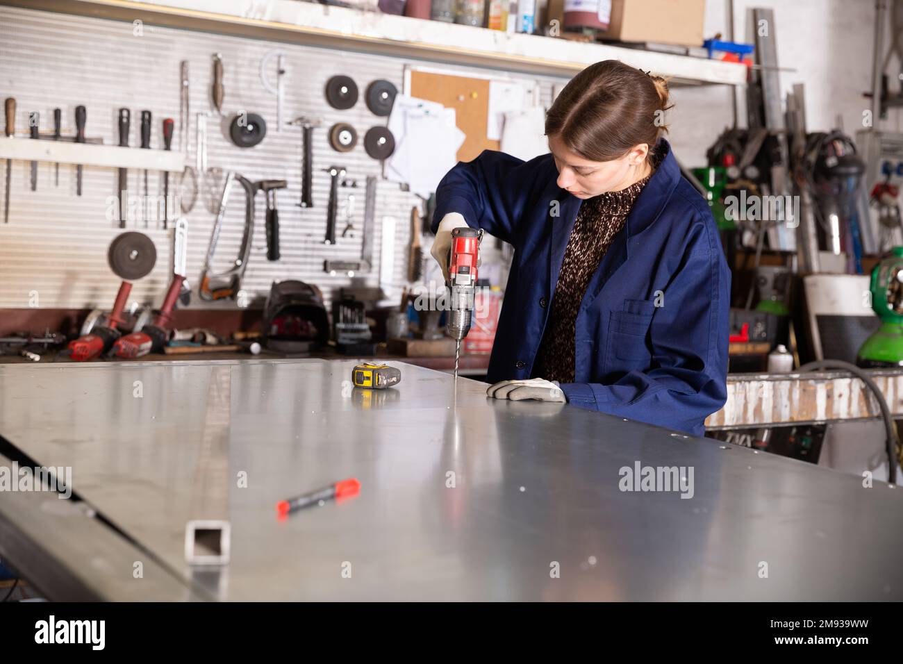 Woman working with metal sheet and using electric drill Stock Photo - Alamy