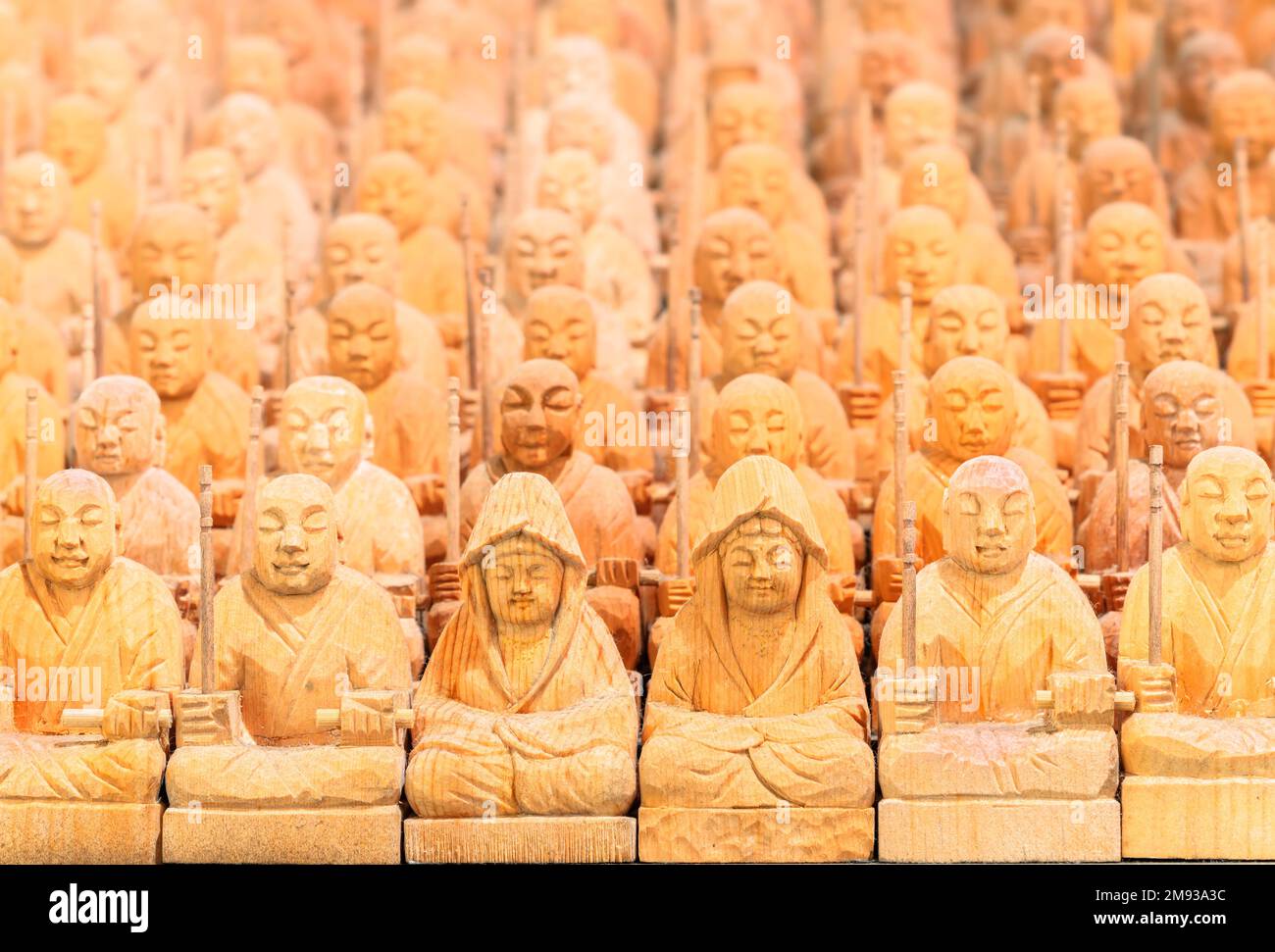 Background full of tiny wooden sculptures depicting buddhist monks ...