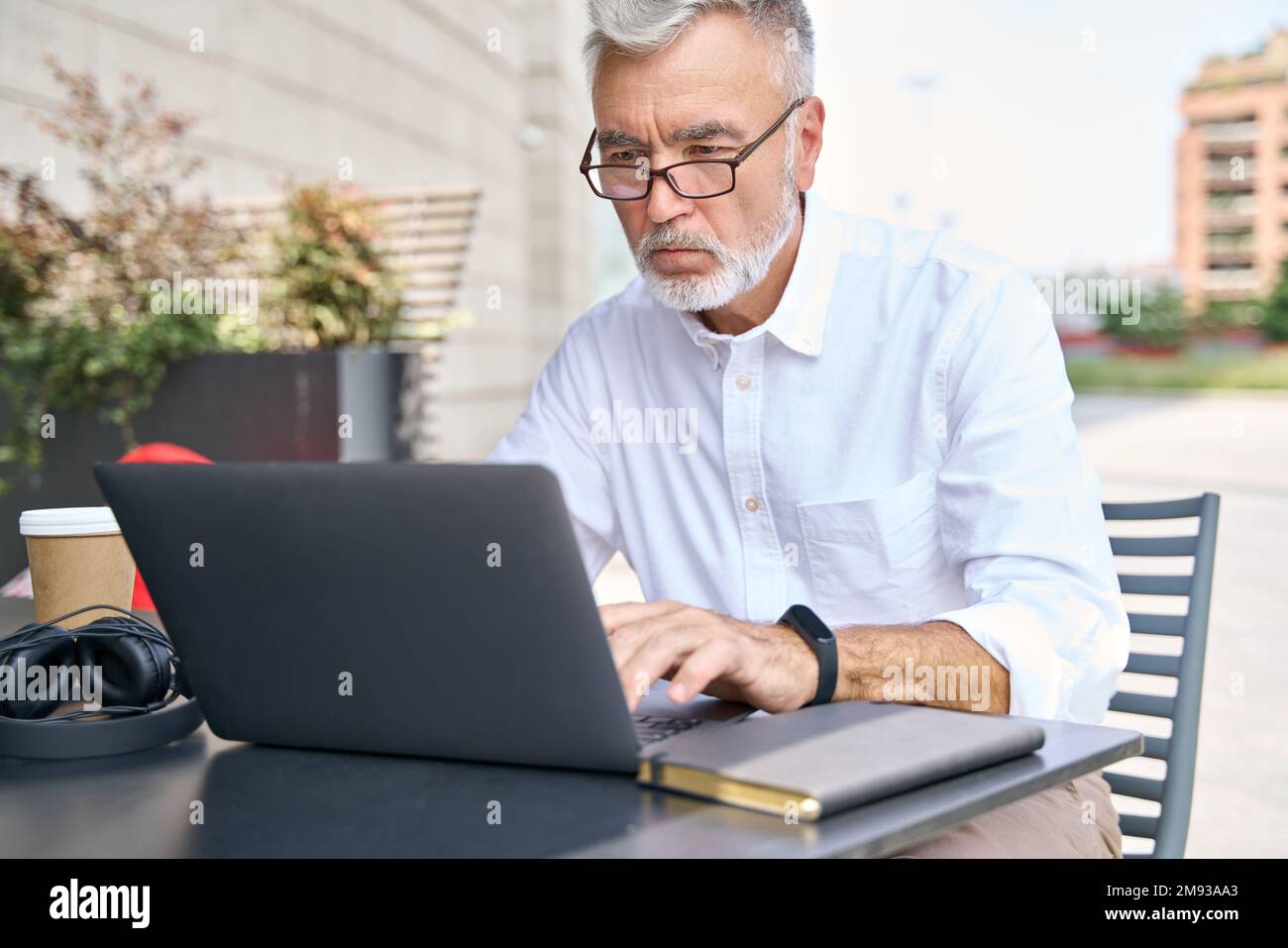 Focused older business man using computer working online outdoor Stock ...