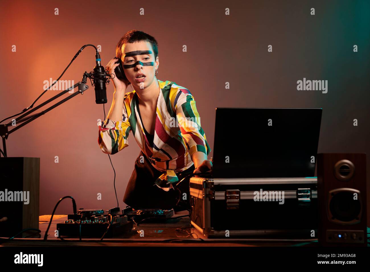 Happy musician playing with techno music on mixer, having fun with ...