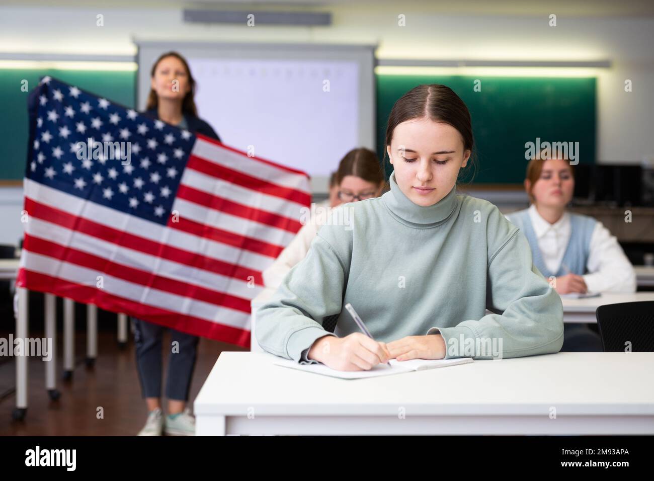 Teacher stands behind students with flag of USA Stock Photo - Alamy