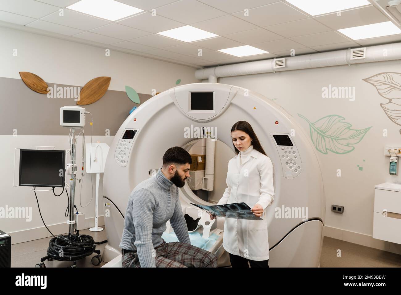 CT Doctor consulting patient and showing x-ray head scan to patient in ...