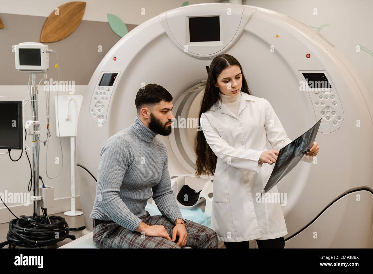 CT scan radiologist showing x-ray of brains to man patient in computed ...