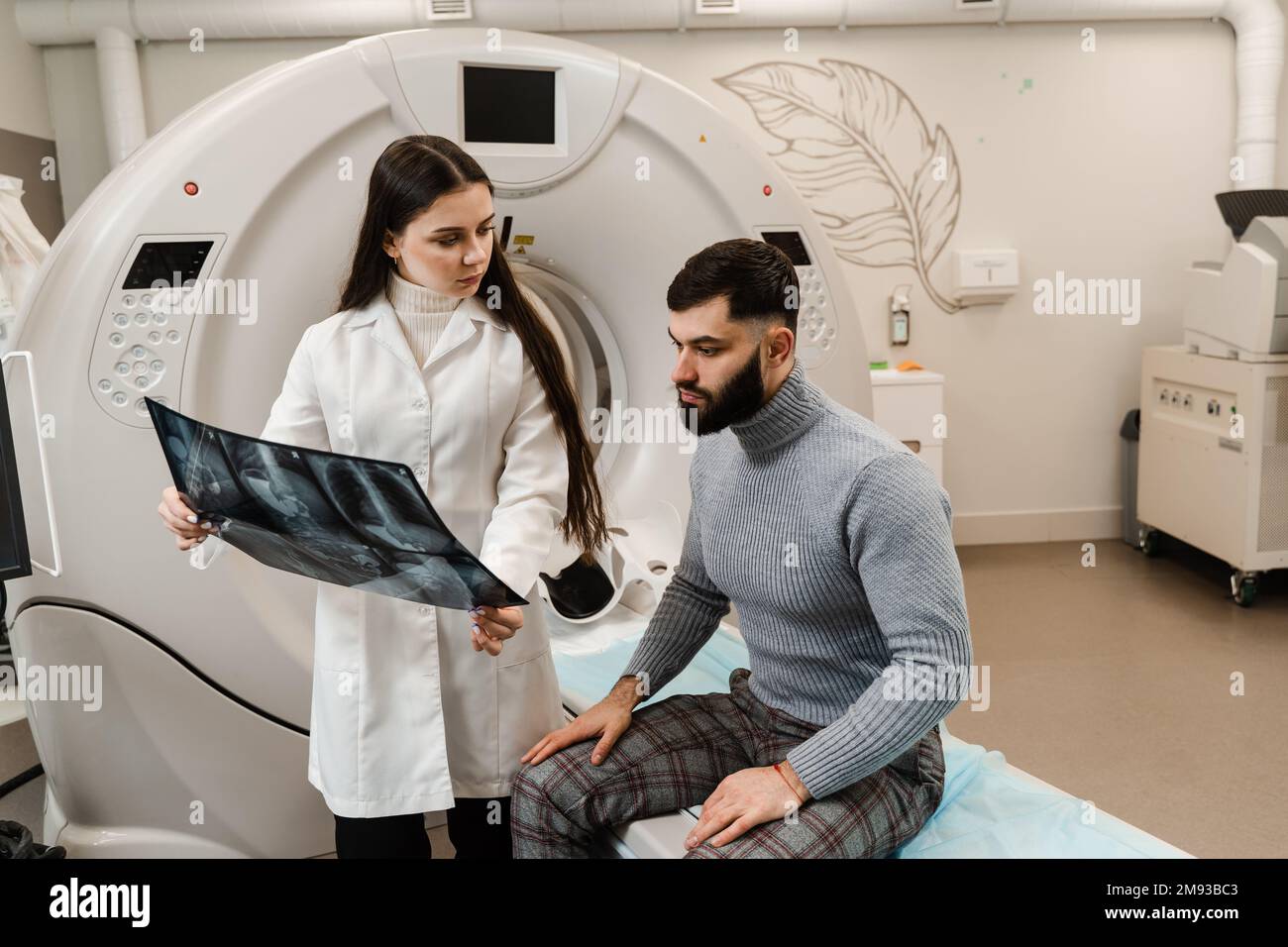 CT scan radiologist showing x-ray of abdomen to man patient in computed ...