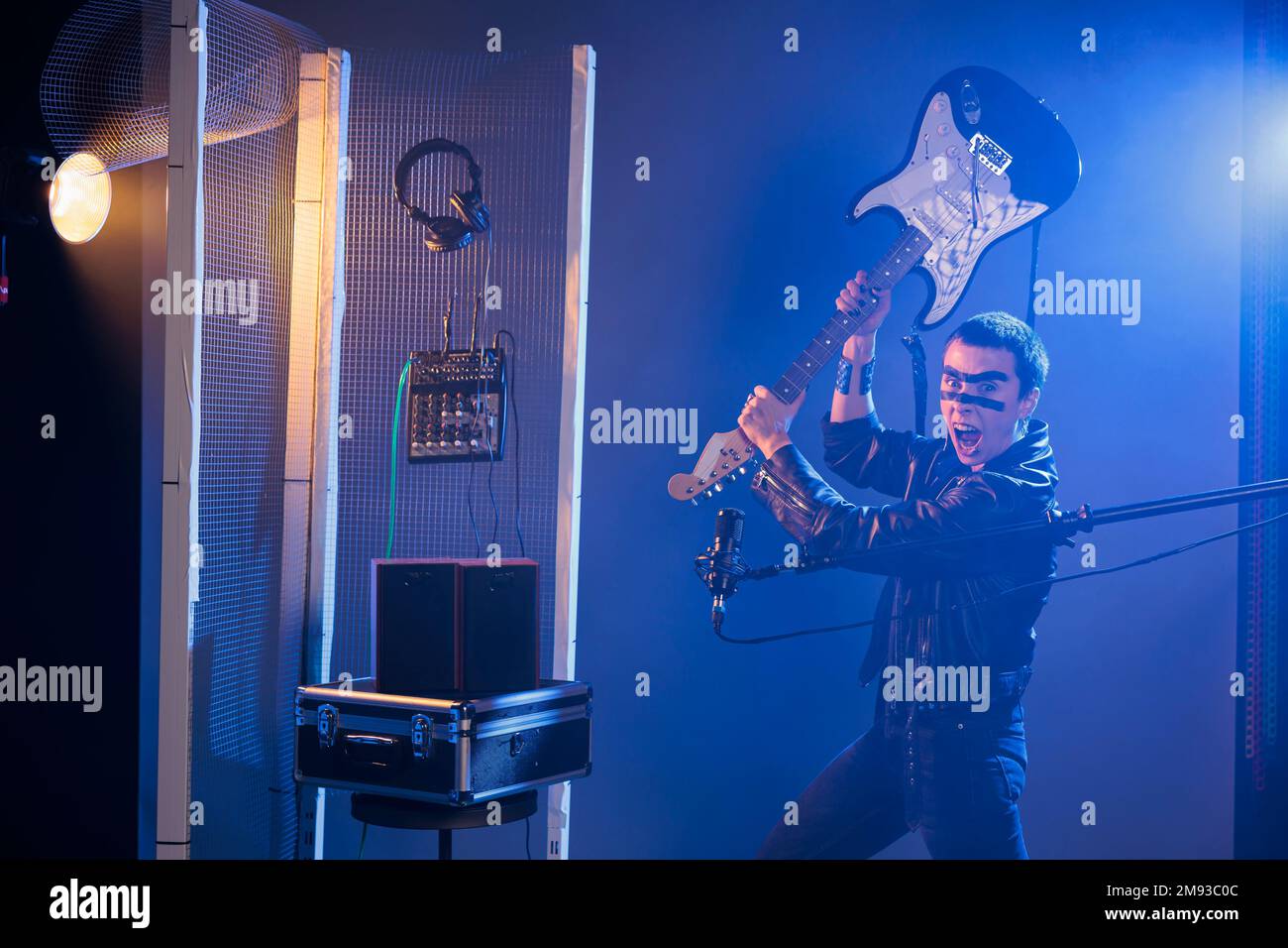 Ecstatic artist holding bass guitar to smash and act crazy, performing ...