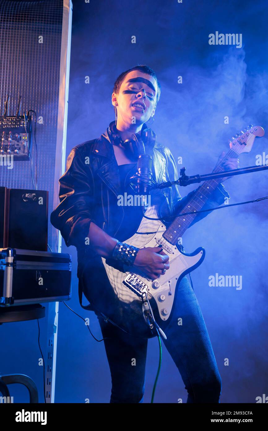 Talented stylish rocker playing guitar and singing heavy metal music at ...