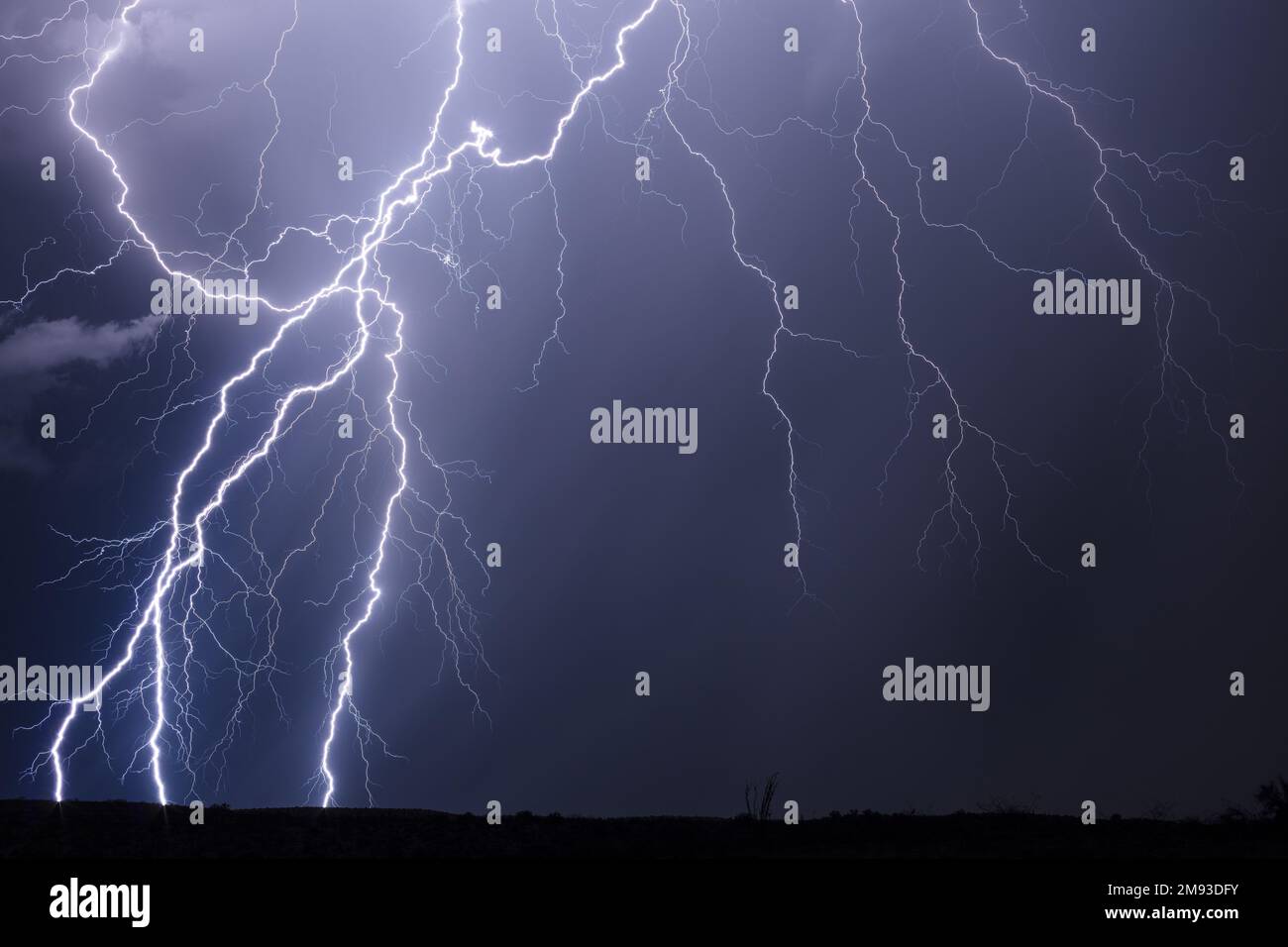 Lightning bolts strike in the night sky from a thunderstorm near ...