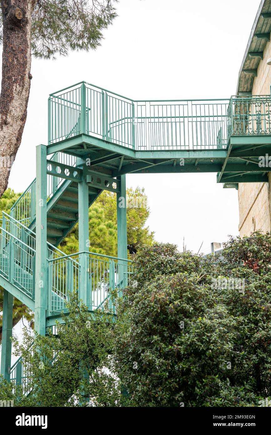 Green and exterior metal stairs to the building. stairs outside of a ...