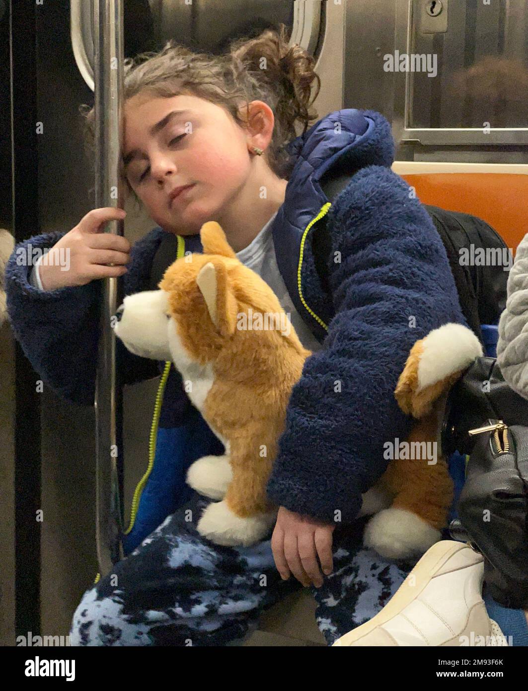 Sleepy young girl with her doll on a New York City subway train Stock ...