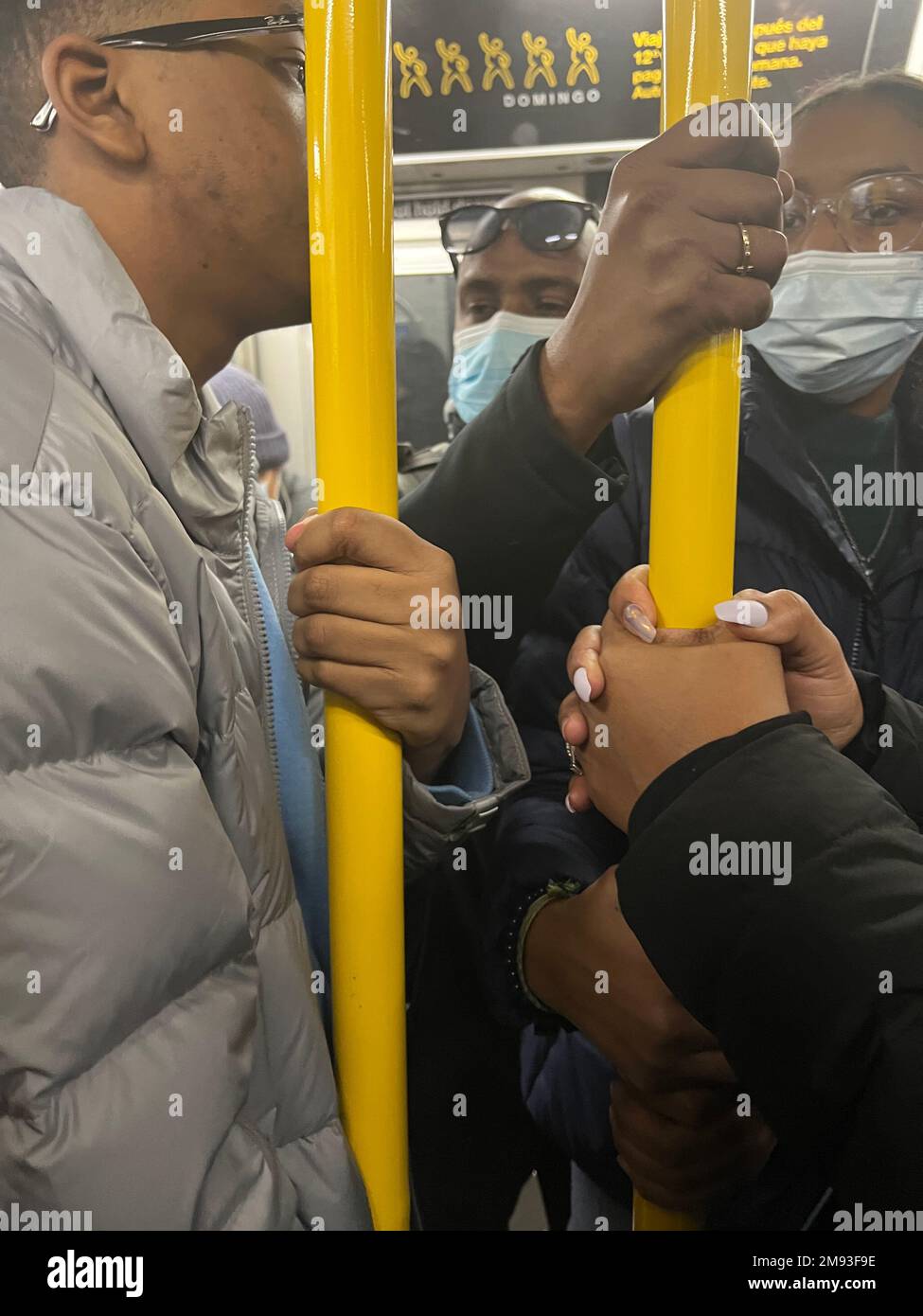 People hold on while standing on a crowded subway train in Manhattan ...