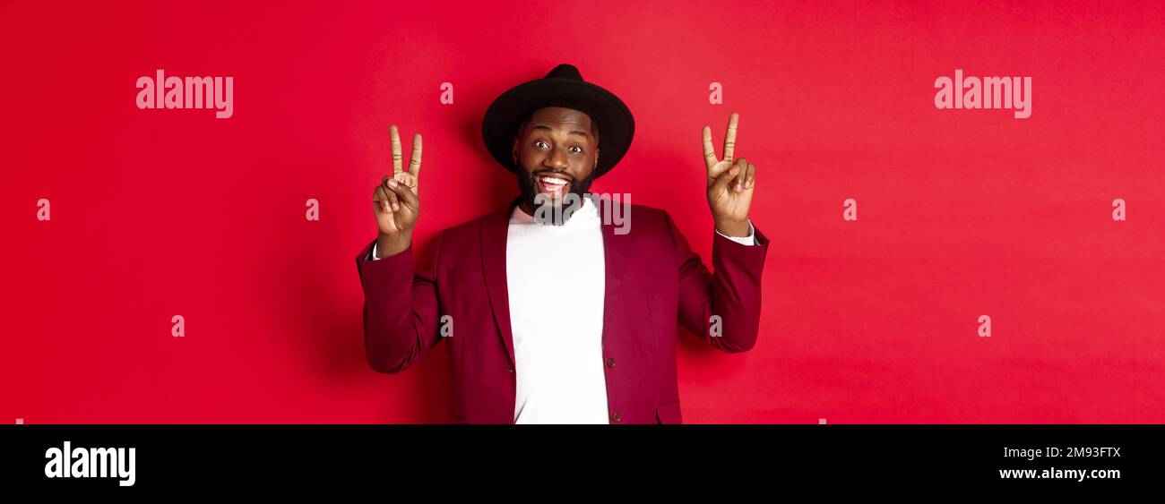 Fashion and party concept. Handsome Black man having fun, showing peace ...