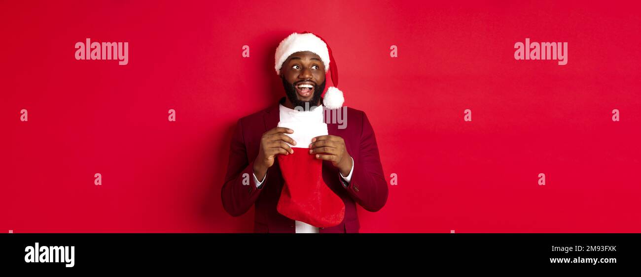 Cheerful Black man looking upper left corner and smiling, holding ...
