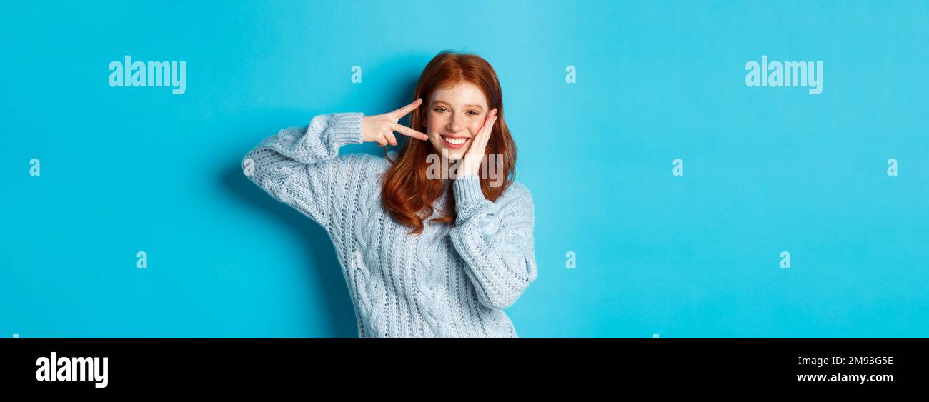 Cheerful redhead female model sending good vibes, smiling and showing ...