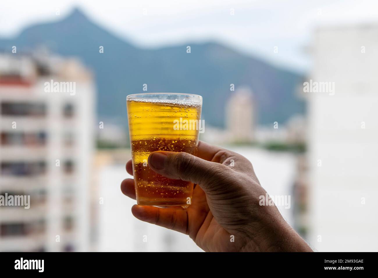 Man holding glass of beer on blurred urban city background with ...