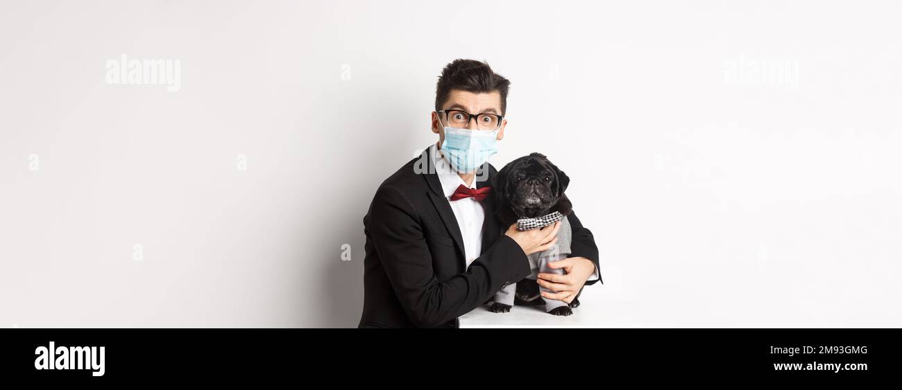 Coronavirus, pets and celebration concept. Happy dog owner in suit and ...