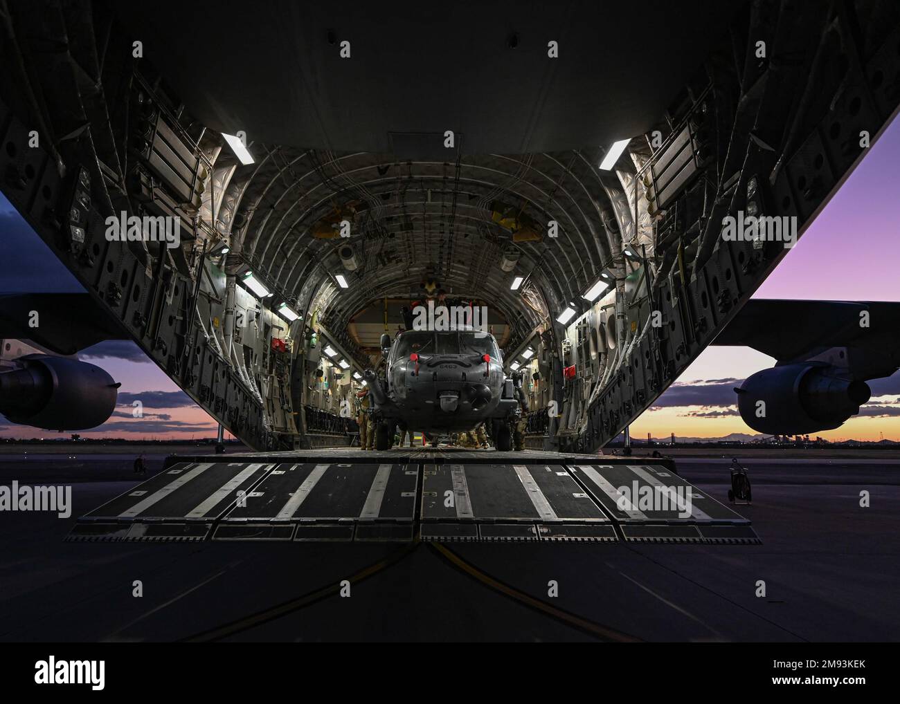 Airmen unload an HH-60G Pave Hawk from a C-17 Globemaster III assigned ...
