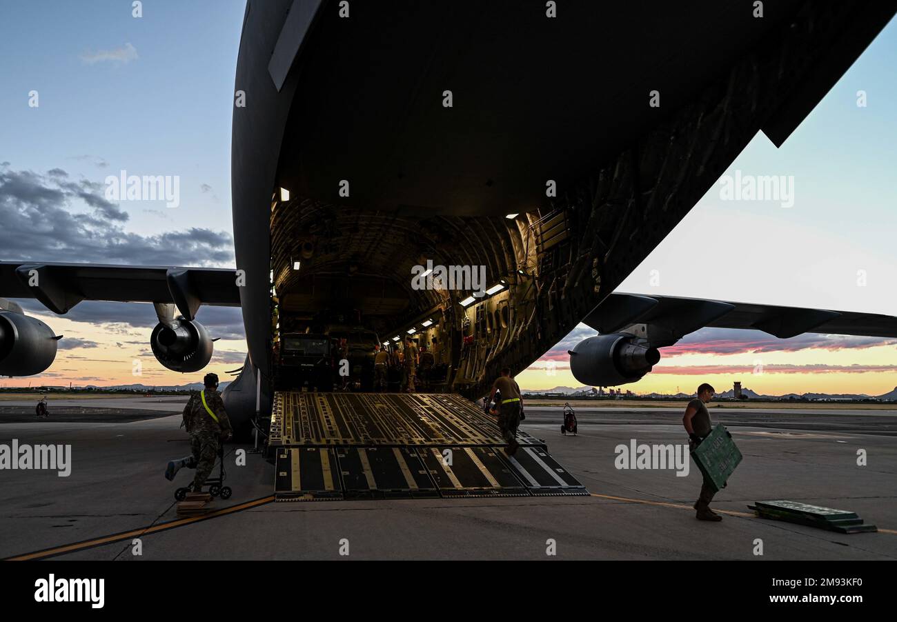Airmen unload an HH-60G Pave Hawk from a C-17 Globemaster III assigned ...
