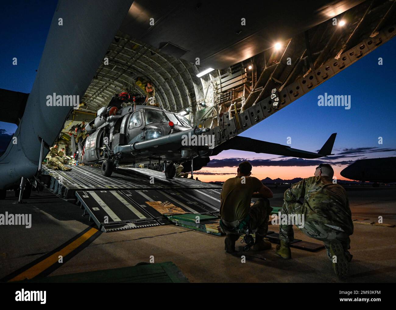 Airmen unload an HH-60G Pave Hawk from a C-17 Globemaster III assigned ...