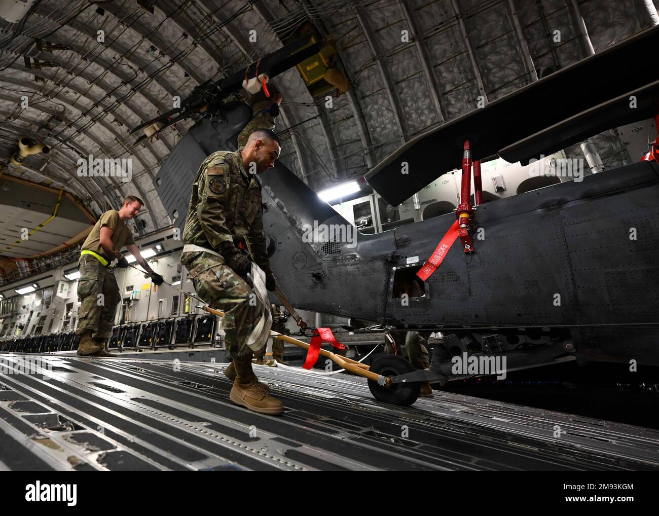 Airmen unload an HH-60G Pave Hawk from a C-17 Globemaster III assigned ...