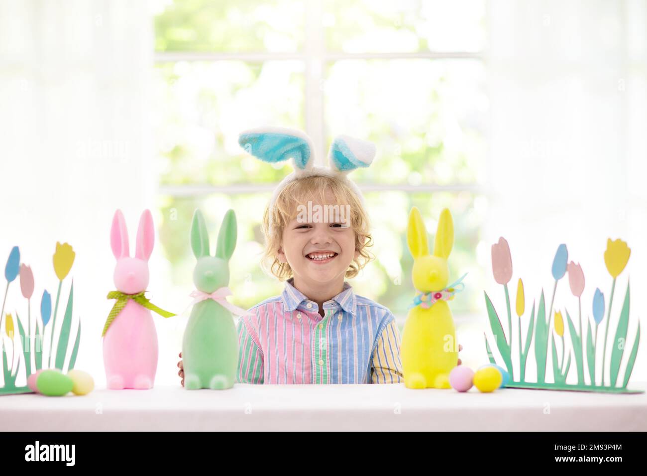 Kids dyeing Easter eggs. Children in bunny ears dye colorful egg for ...