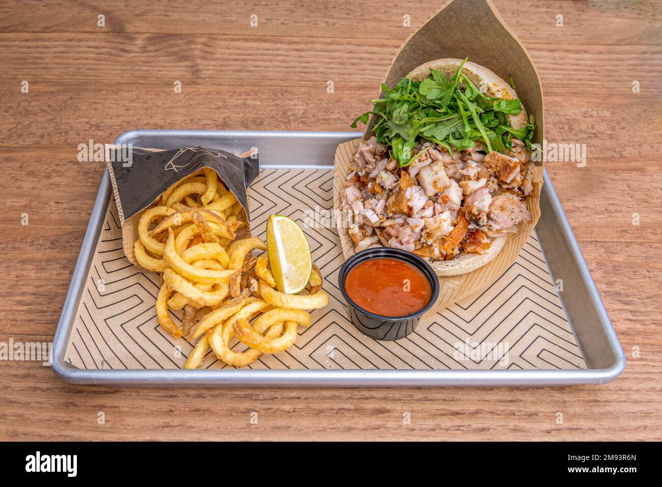 Tray with a large sandwich of chopped grilled meat, rocket in quantity ...