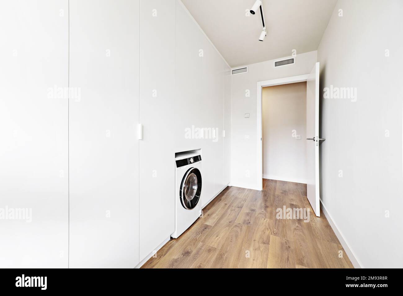 Room dedicated to laundry room and iron with washing machine built into ...