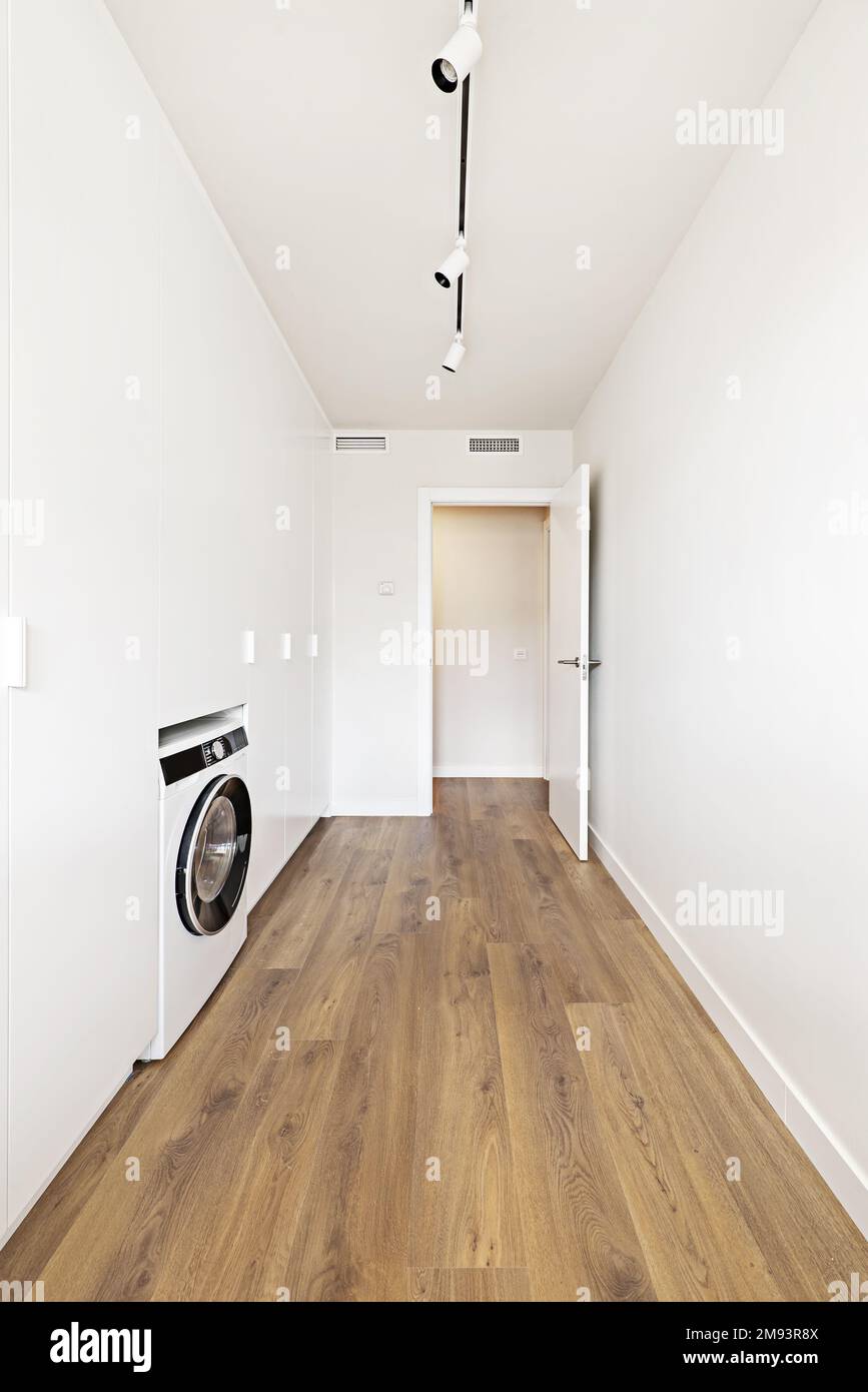 Room dedicated to laundry and iron with a washing machine built into a ...