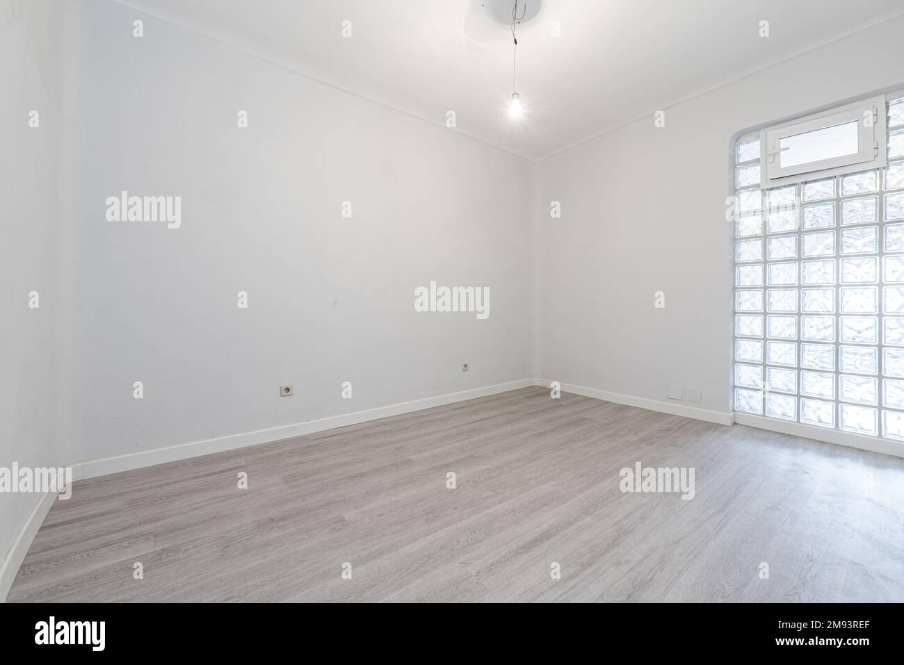 Empty room with skylight wall made of square glass pavers and light ...