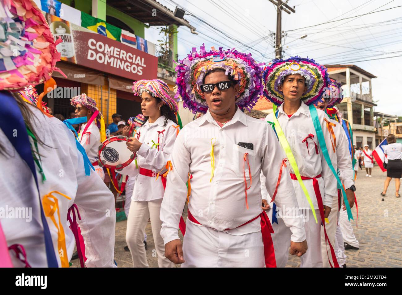 A group of people singing and dancing during a parade on the streets of ...