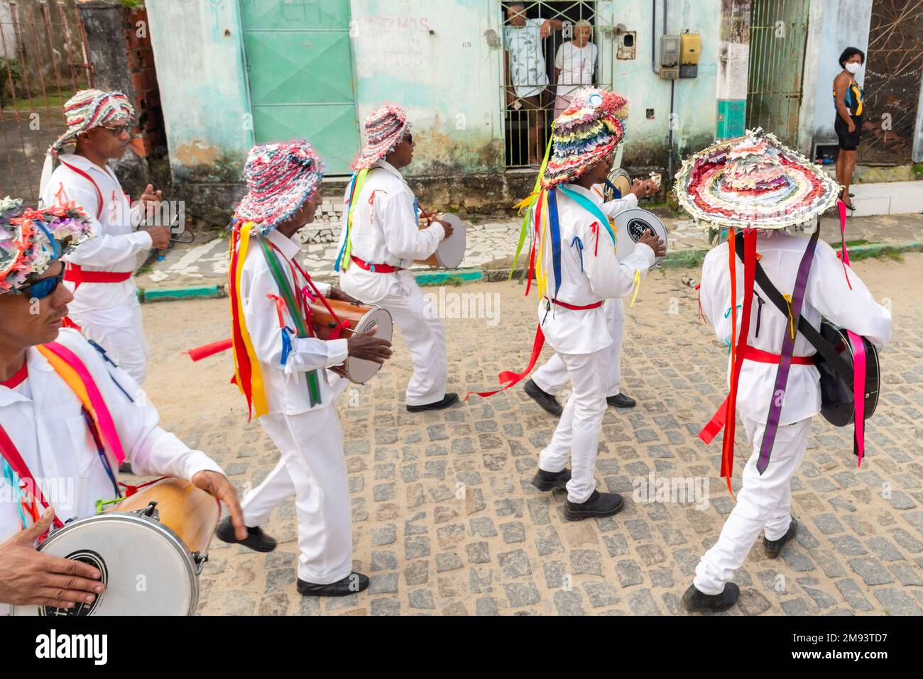 A group of people singing and dancing during a parade on the streets of ...