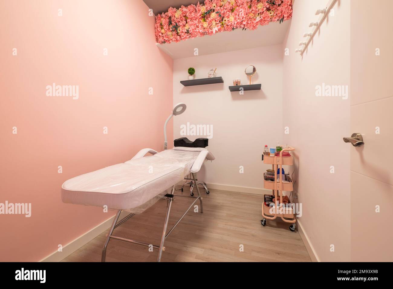 Massage cabin with folding table in a beauty salon with plain pink ...