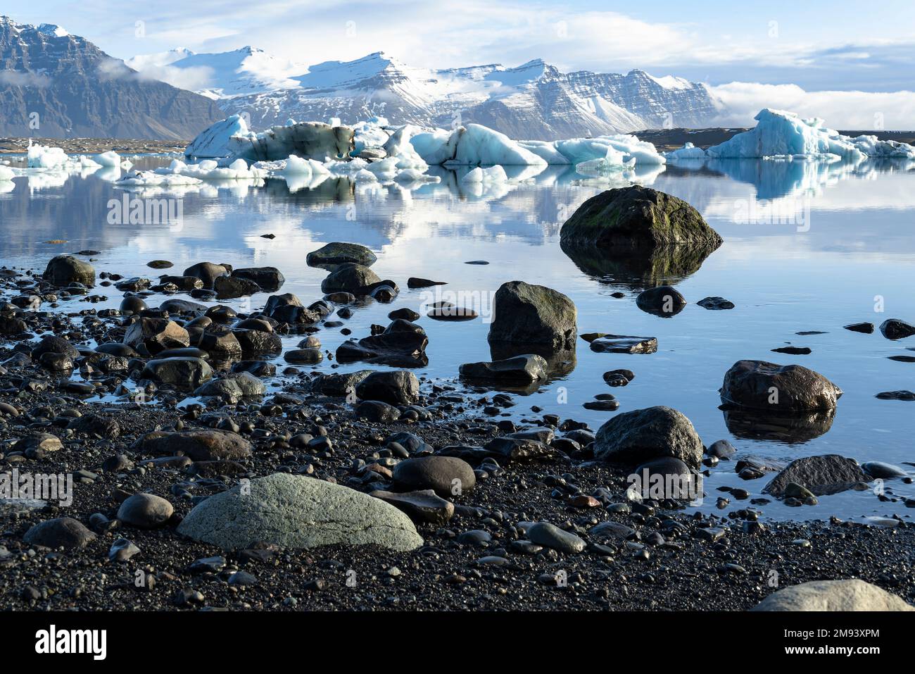 Shore of Jökulsárlón glacier lagoon with black rocks and boulders ...