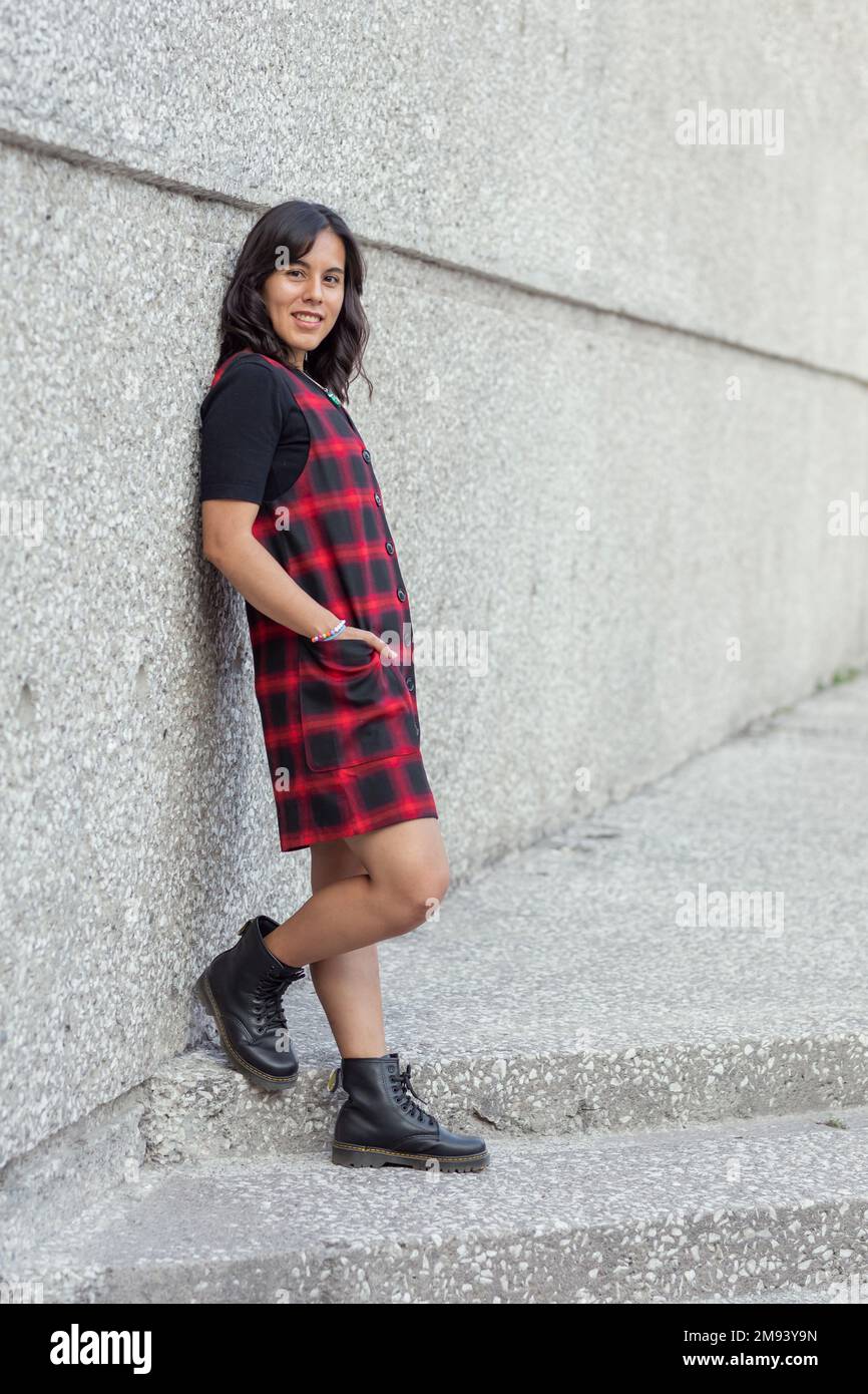 Portrait of a Mexican woman with a dress, leaning against the wall of a museum, with copy space ...