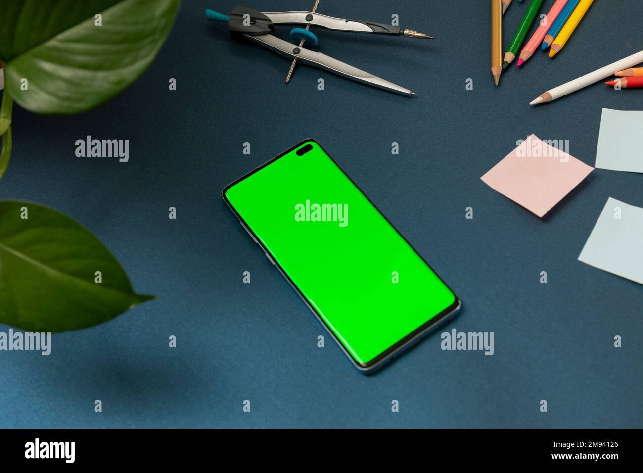 cell phone with green screen to put advertising, on a desk with office ...