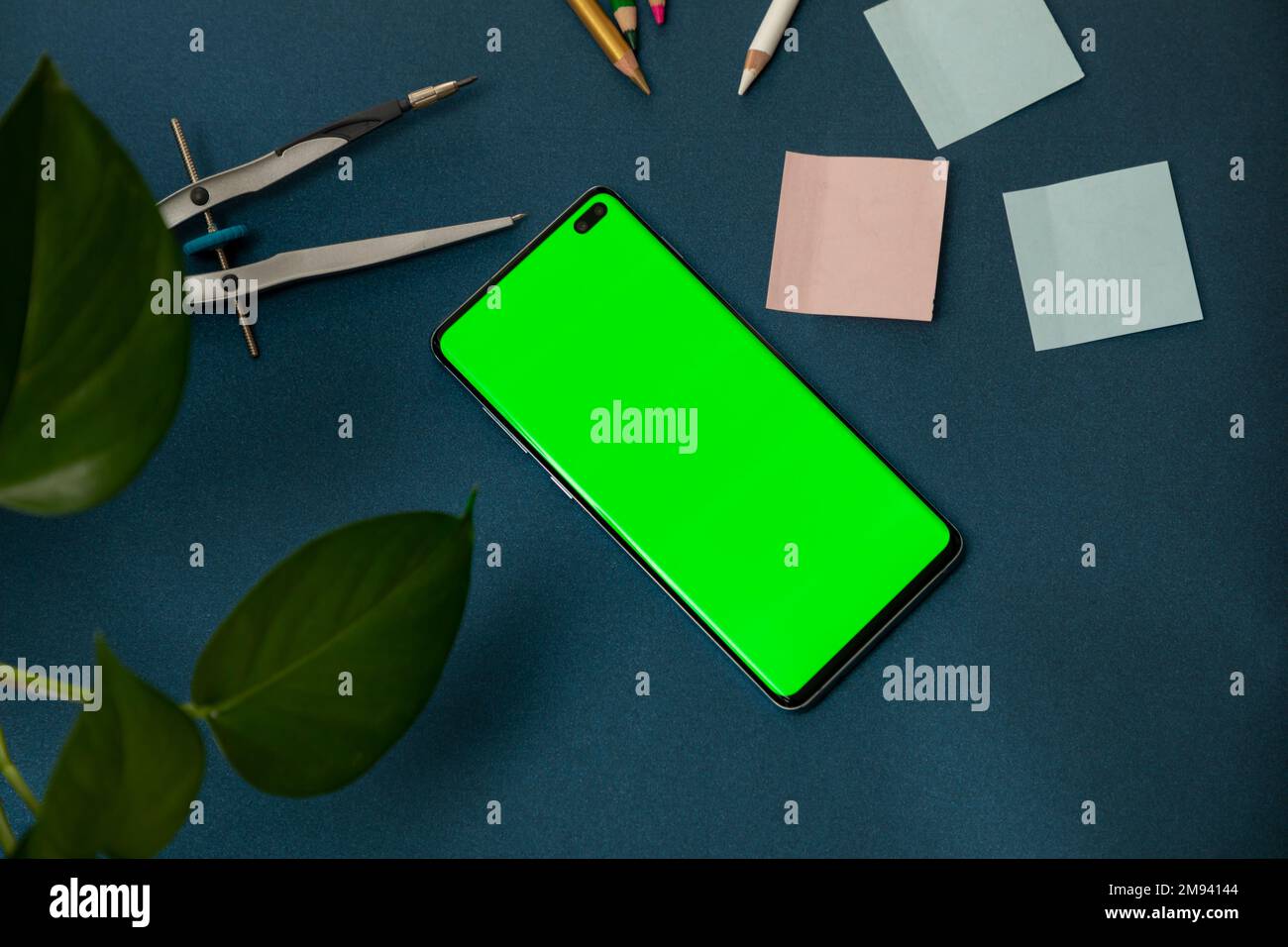 cell phone with green screen to put advertising, on a desk with office ...