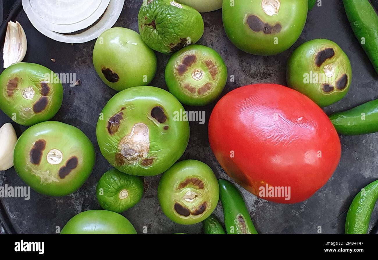 Comal with ingredients to prepare a traditional Mexican sauce, which ...