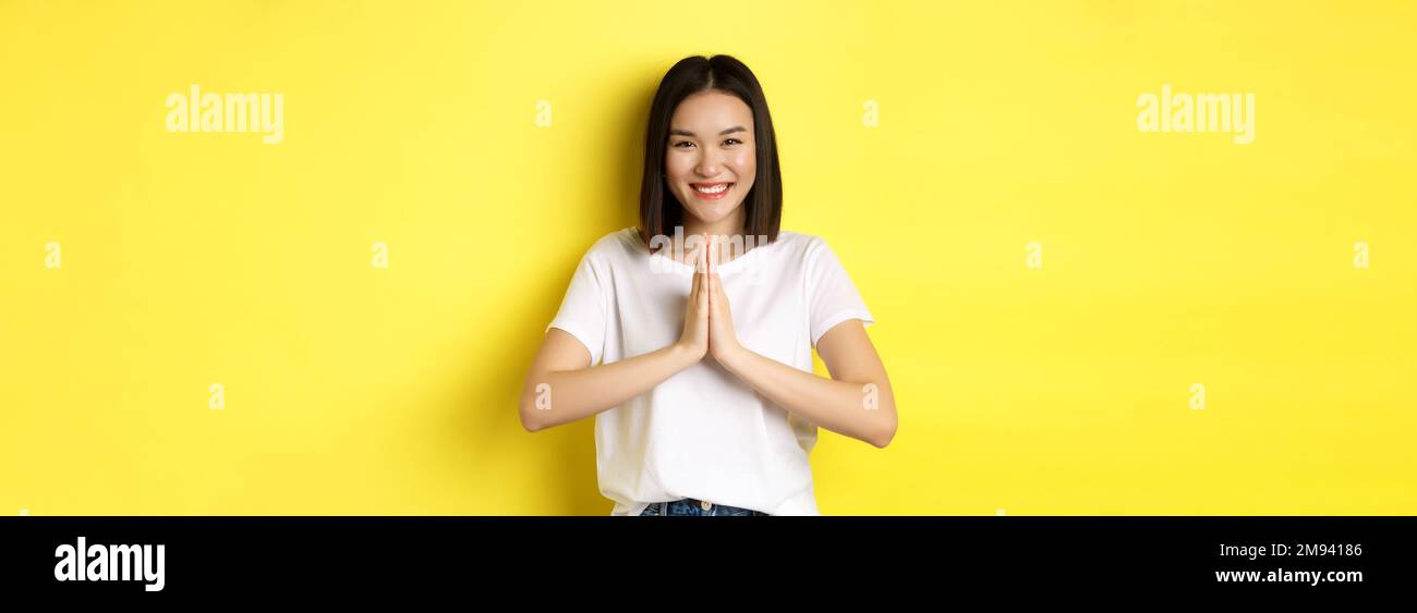 Beautiful asian woman say thank you, holding hands in namaste, pray ...
