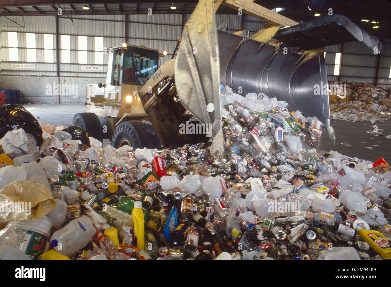 Bulldozer pushing around a large pile of bottles and plastic in a ...
