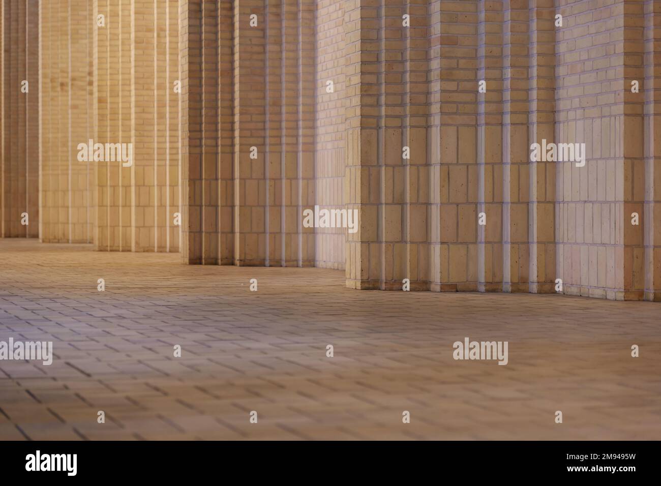 Low angle and selective focus view of cream brick floor, wall and ...