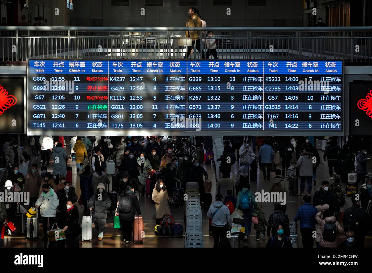 FILE - Travelers walk through a trains departure board at the West ...