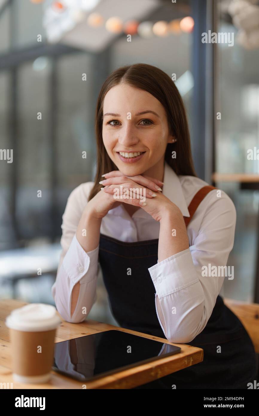 Young Female manager in restaurant with tablet. Woman coffee shop owner ...