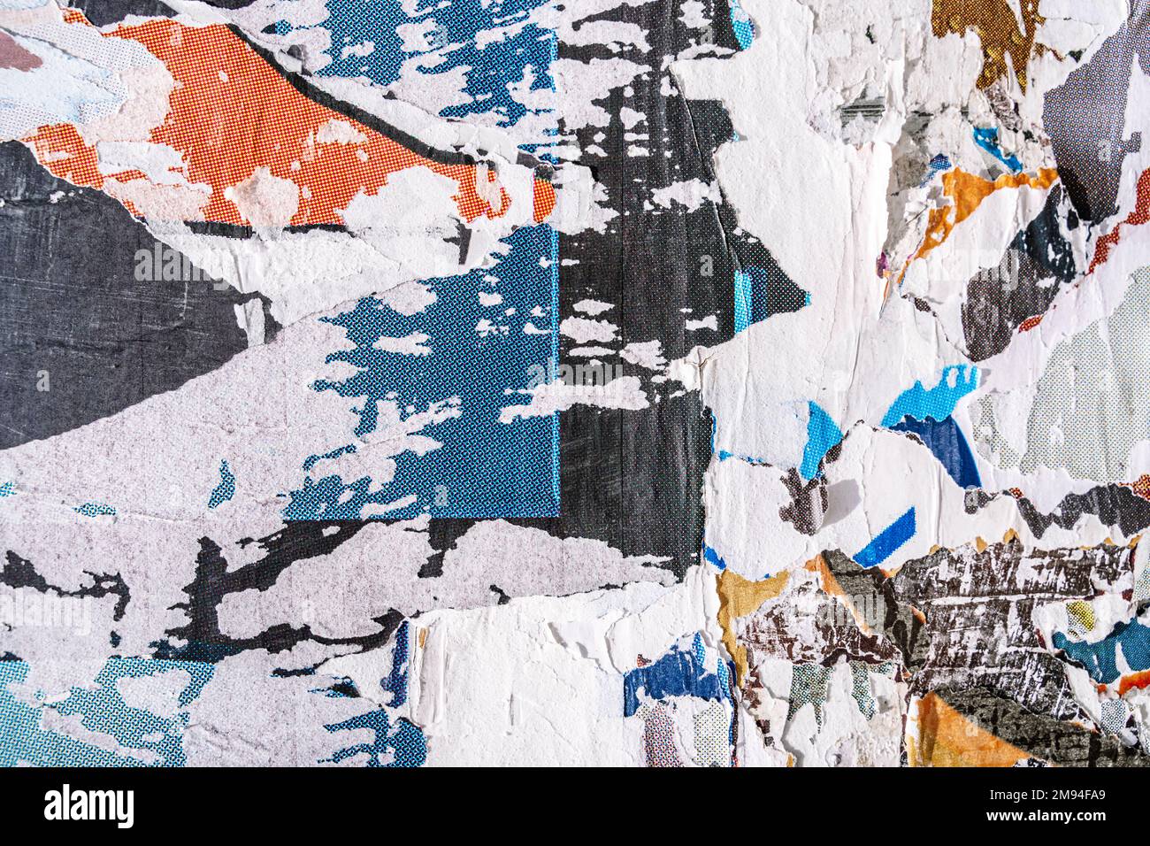 Torn paper collage background on an old poster on a street wall ...