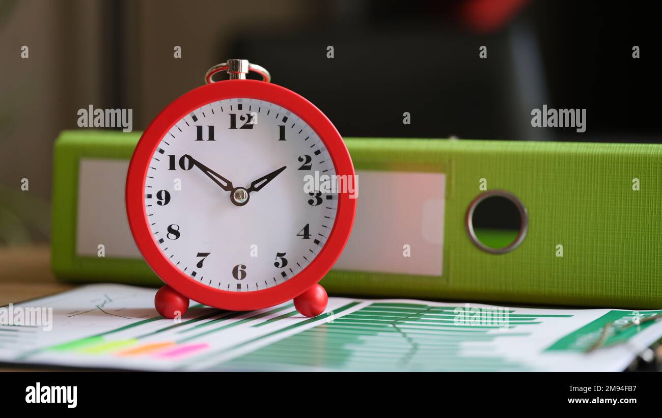 Alarm clock on financial document with charts and graphs Stock Photo ...
