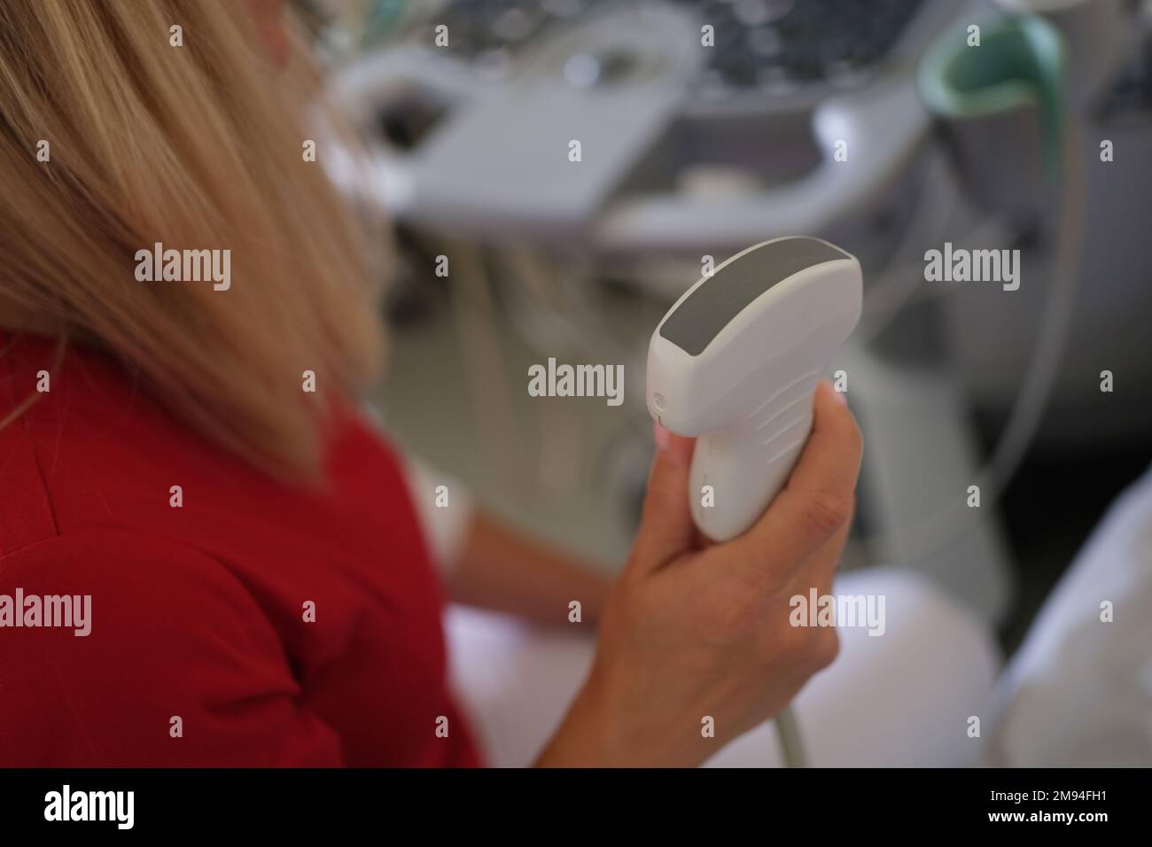 Female doctor holds ultrasound scanner device for examining patient in ...