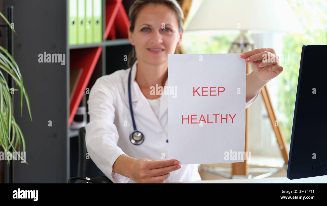 Female doctor showing paper with words keep healthy at her medical ...