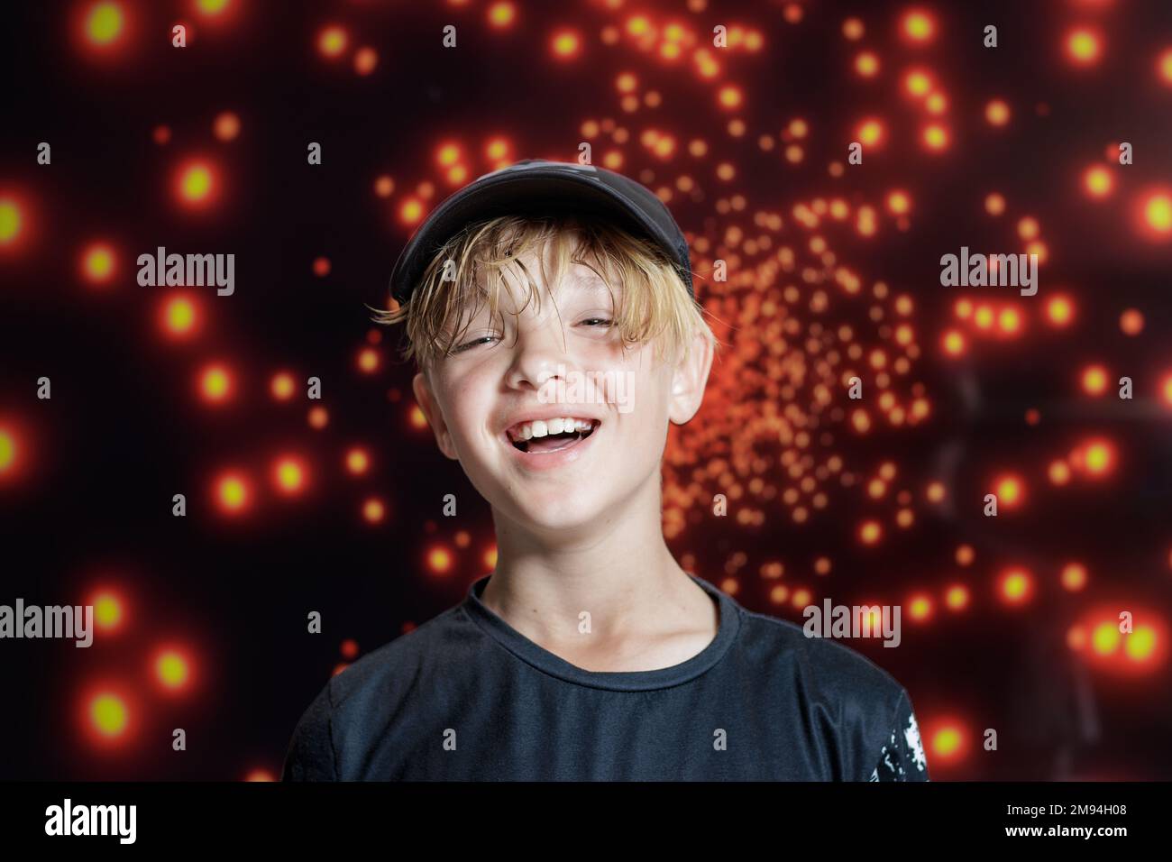Portrait of a beautiful young boy with a baseball cap on in front of a ...
