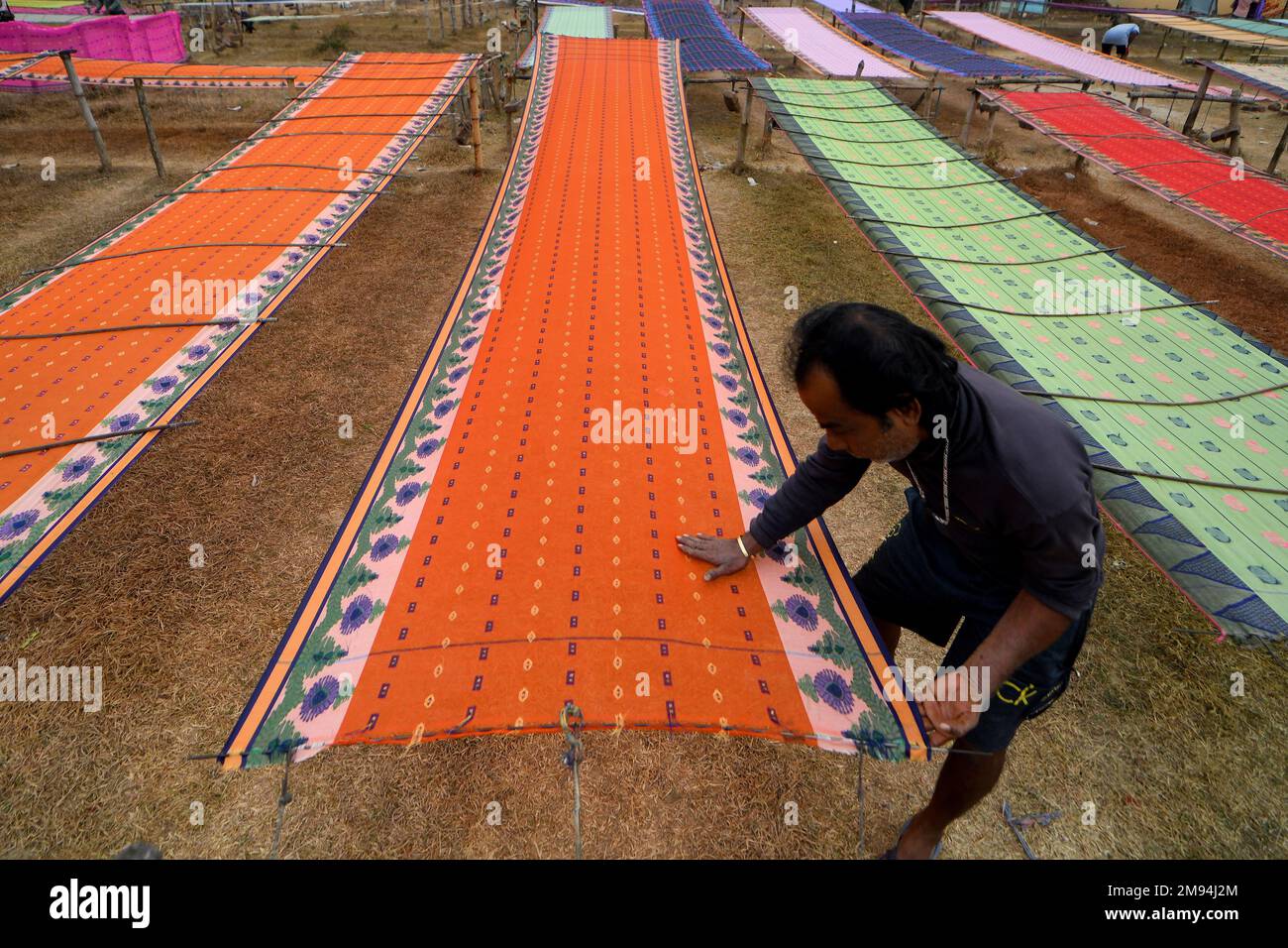 Shantipur, India. 14th Jan, 2023. A weaver seen polishing the threads ...