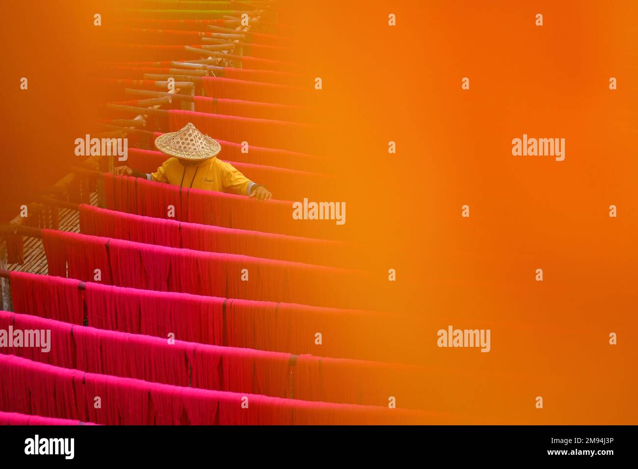 A weaver rinses the colourful Jute fiber to dry under sun which will be ...